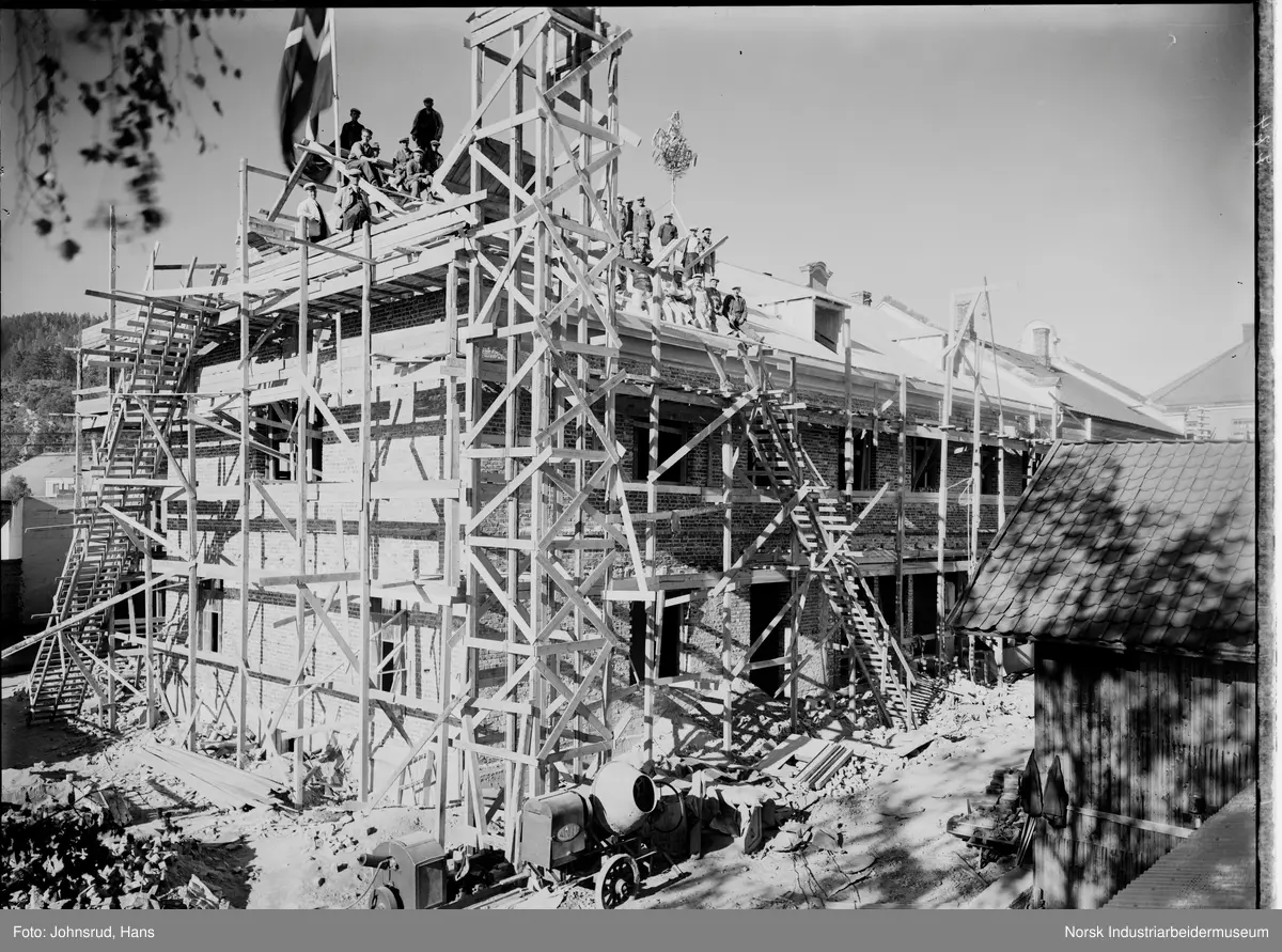 Kranselag ved Notooden meieri. Arbeidere stående på taket av bygningen ...