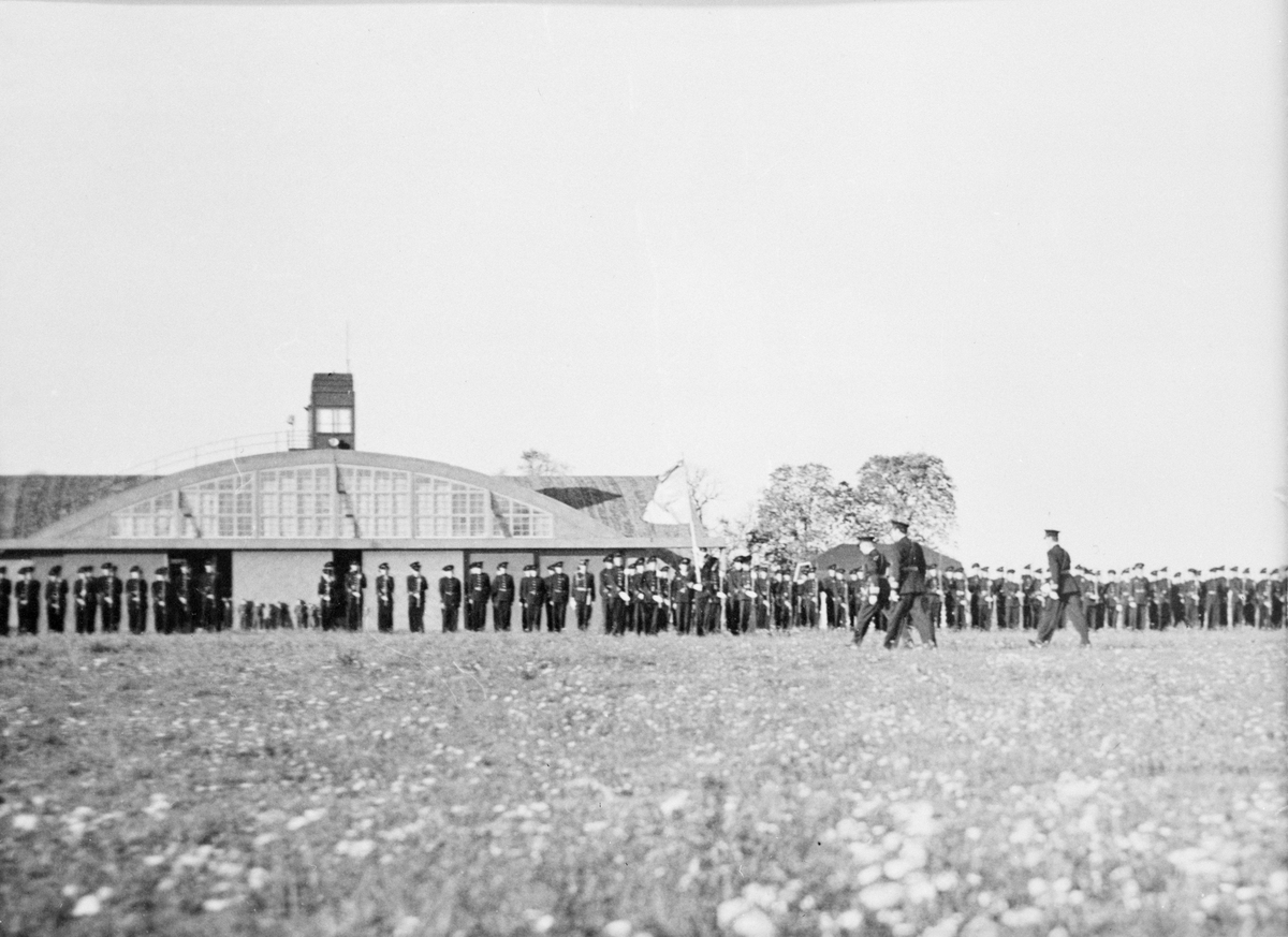 Militärt manskap uppställt framför hangar 81 på F 3 Malmen, 1940-tal ...