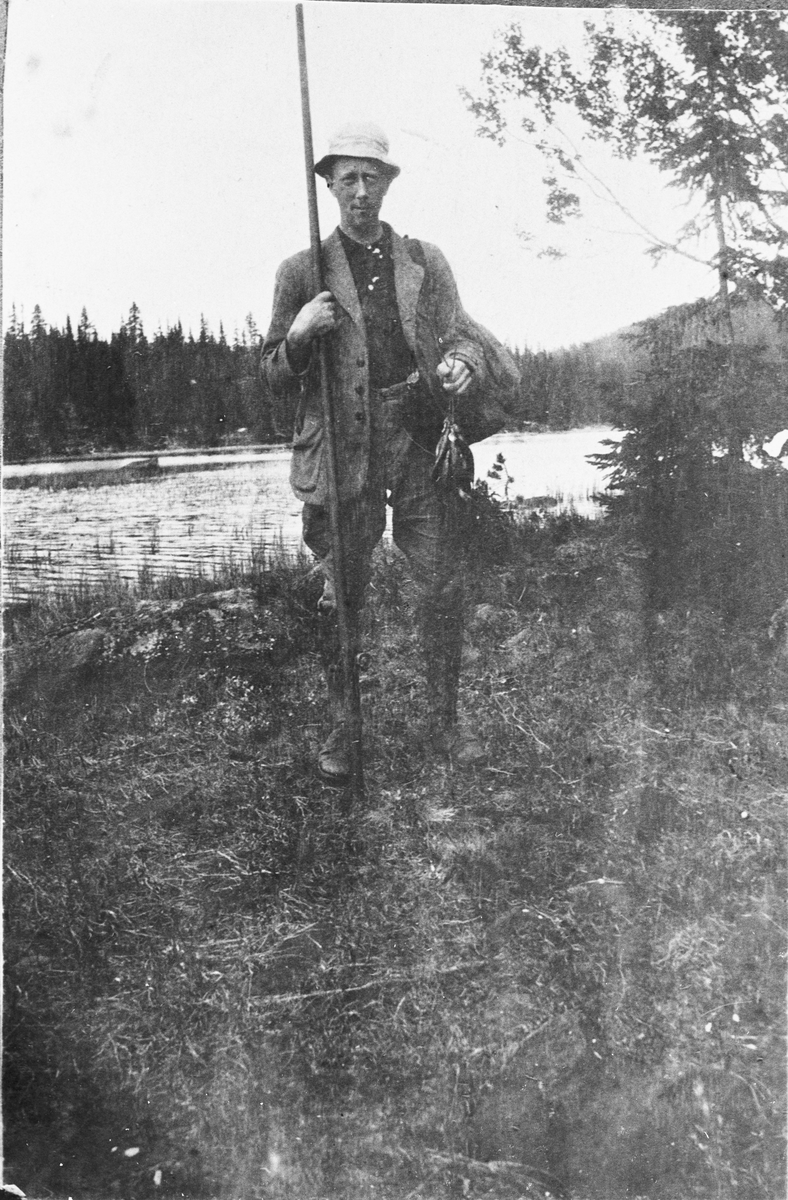 Kristen Kopseng med bambusstang og fiskeknippe, i Eggedal ca. 1920 ...