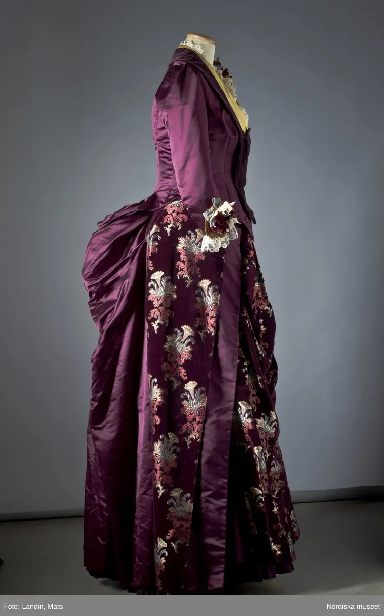 Klänning av mörklila atlassiden med slag av satin och isättning av gul ...