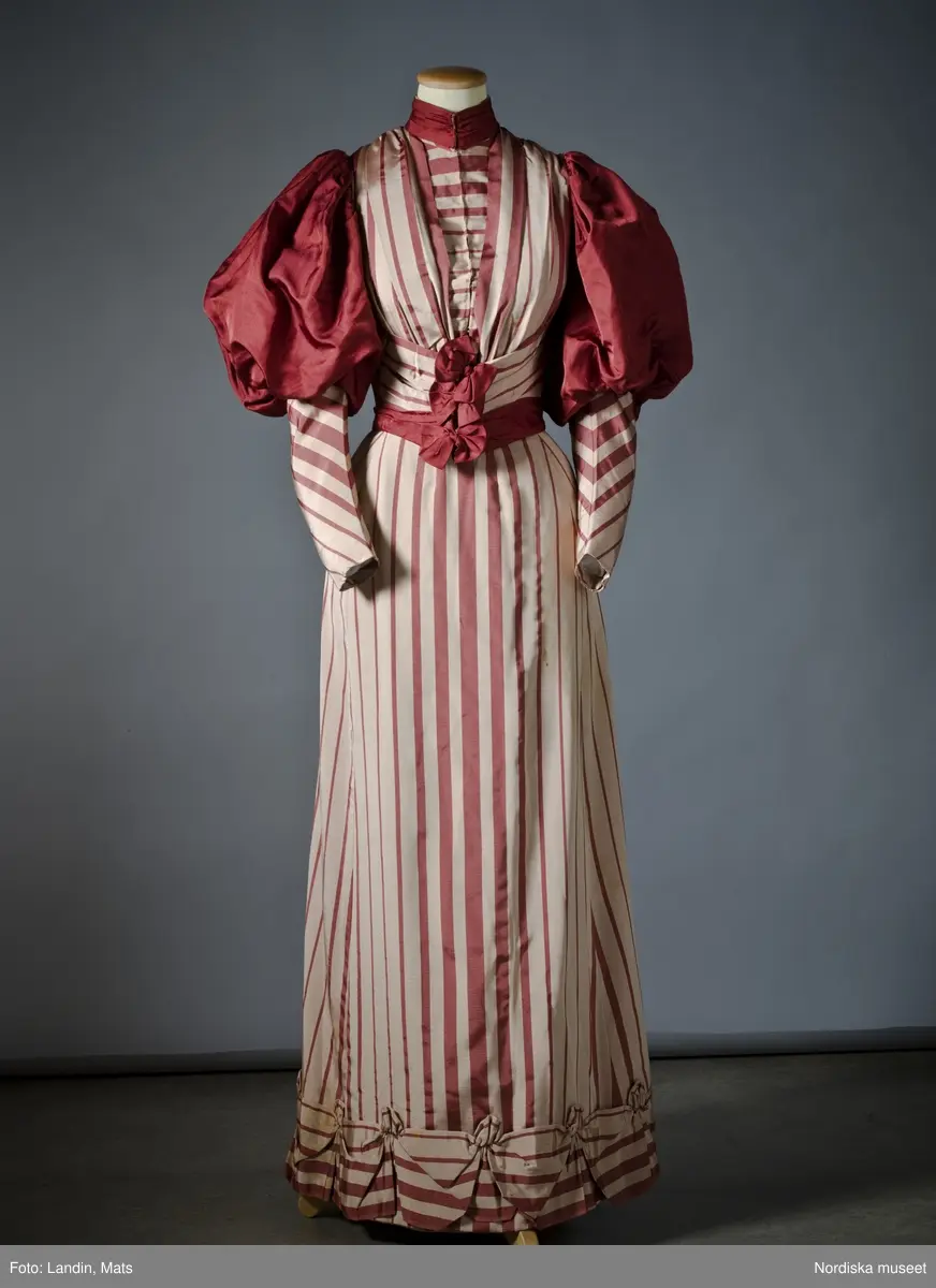 Klänning av ripssiden, röd- och beigerandig med vinröda puffärmar. 1890 ...