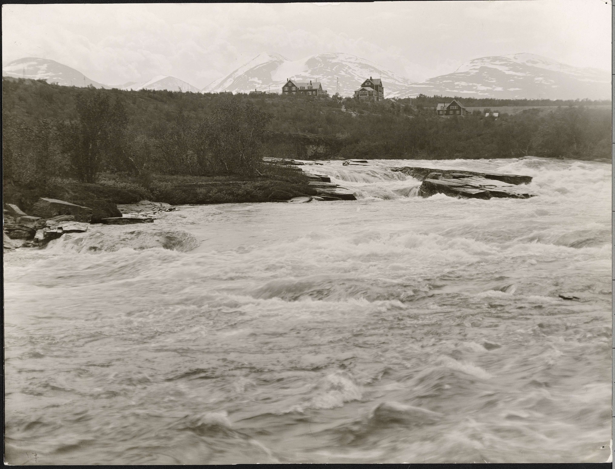 Abisko. Vy mot turiststationen med forsar i förgrunden, fjäll i ...