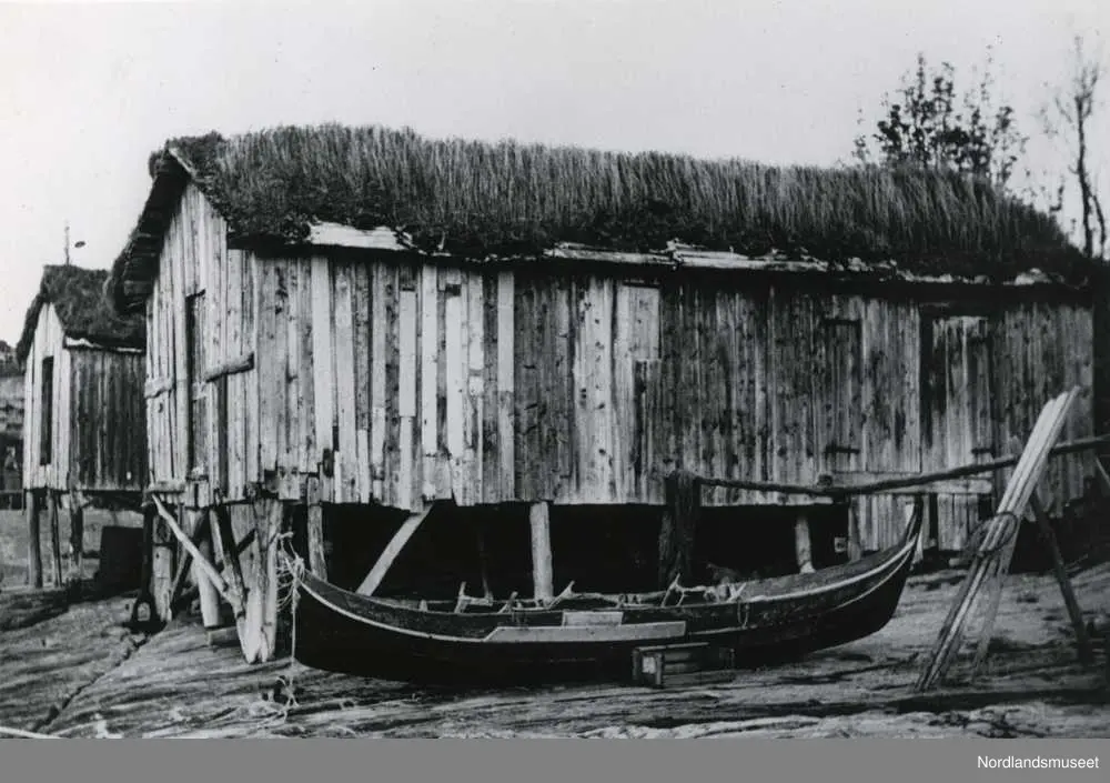 Saltstraumen. To gamle naust med torvtak, straumbåt i forgrunnen ...