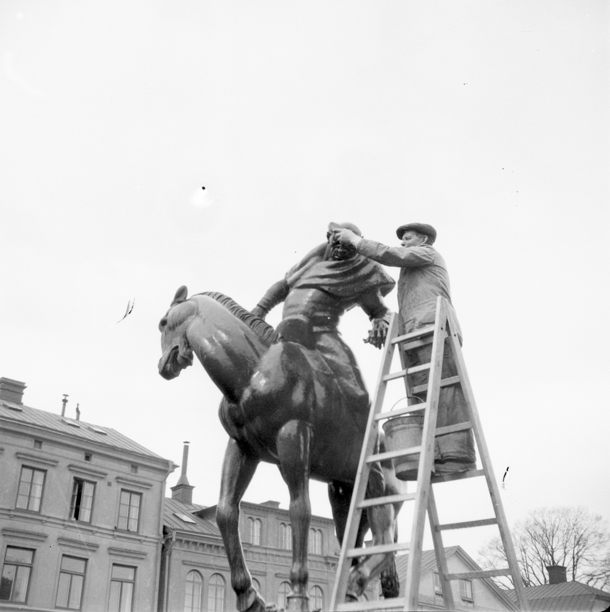 Man på stege tvättar Folke Filbyter i Folkungabrunnen på Stora torget ...