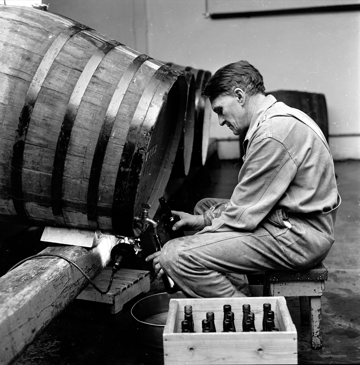 Hasle, Oslo, desember 1963. Vinmonopolet. Tapping fra fat til flasker ...